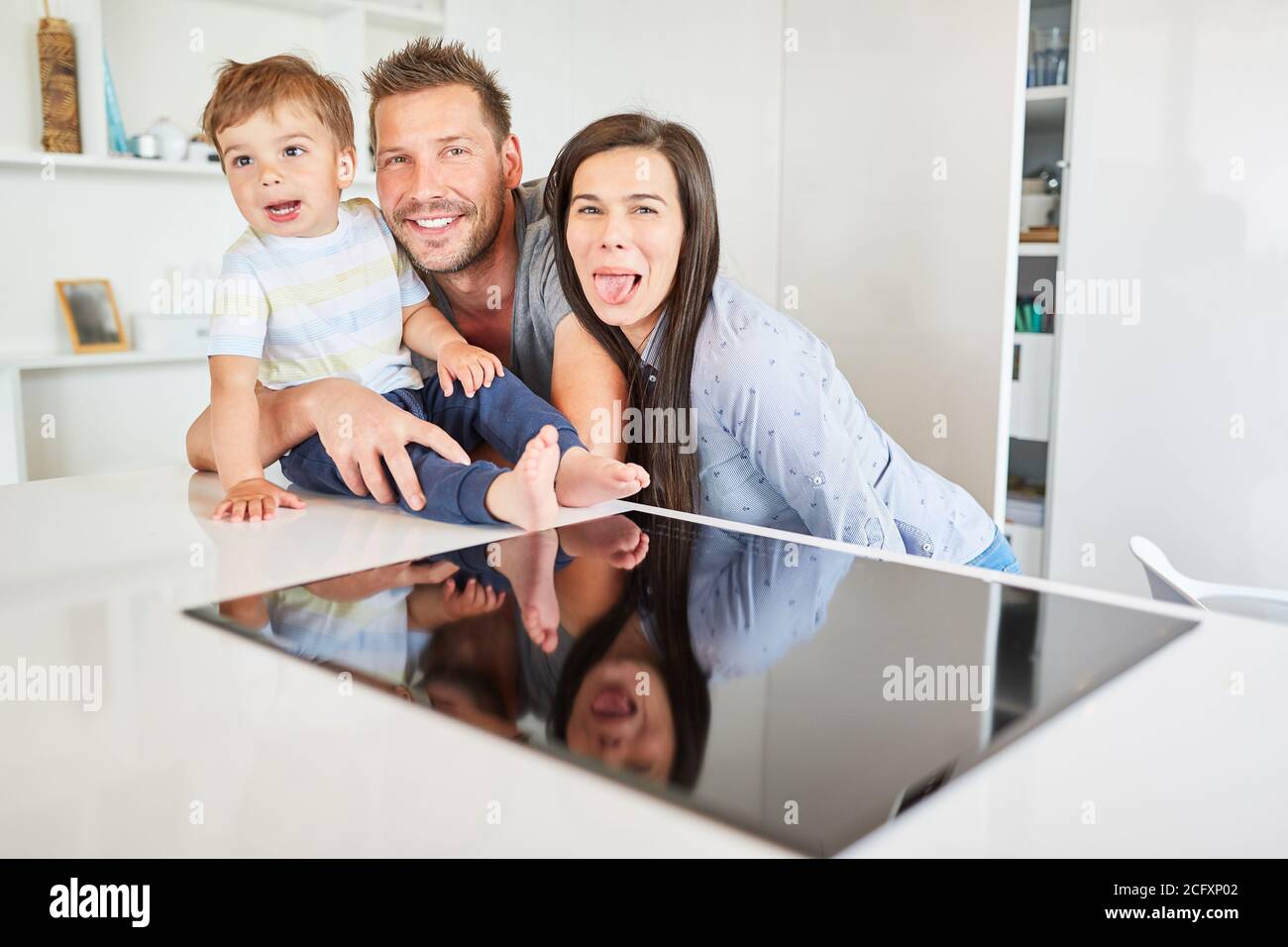 Happy parents fooling around and making mischief with their son in the ...