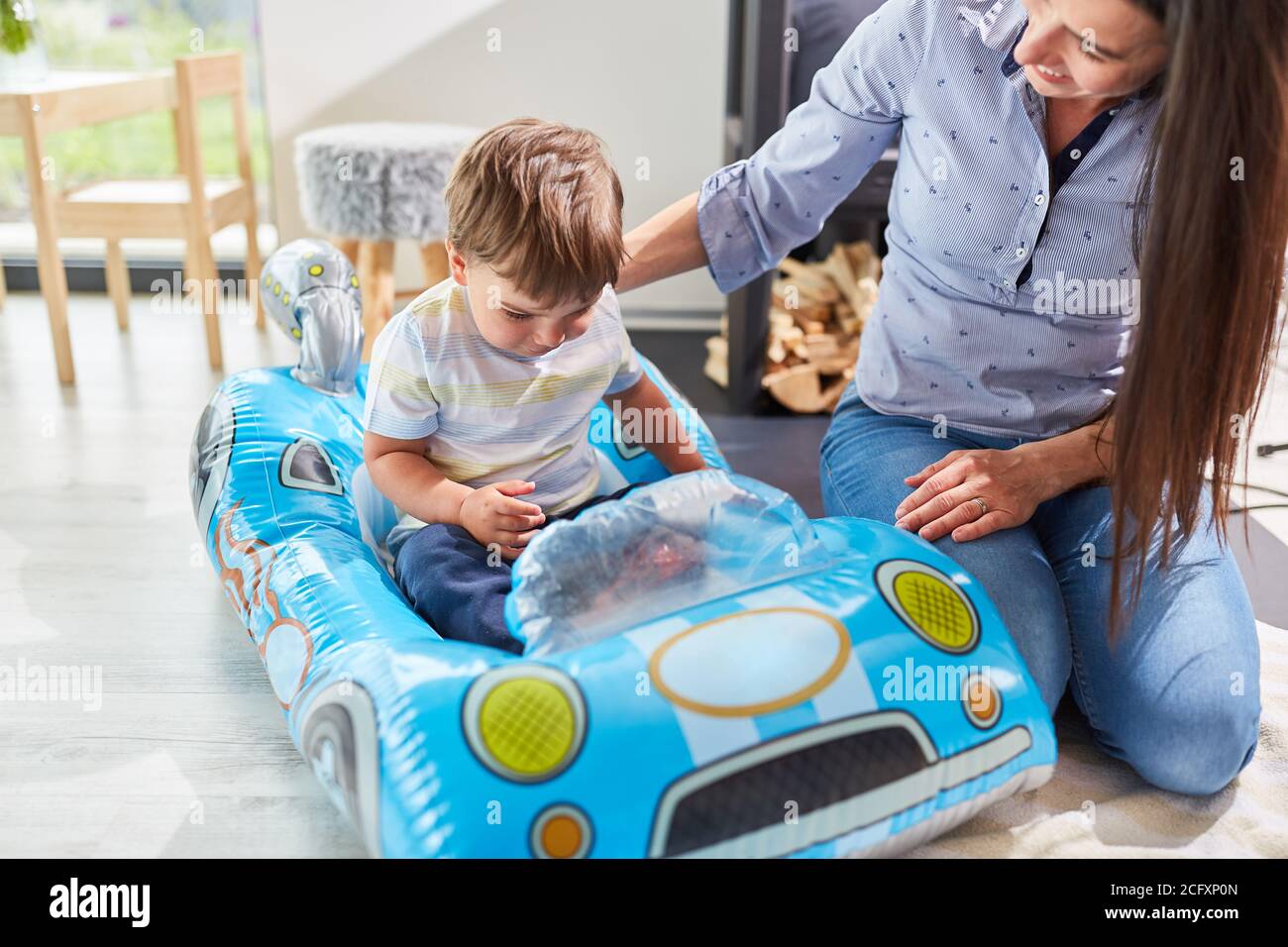 Child drives in the inflatable racing car with mother as supervision in ...