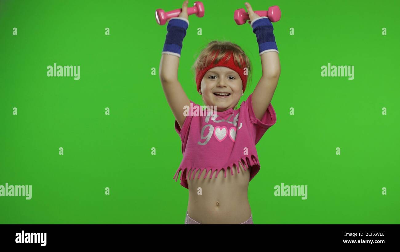 Young caucasian girl in pink sportswear making fitness exercises with ...