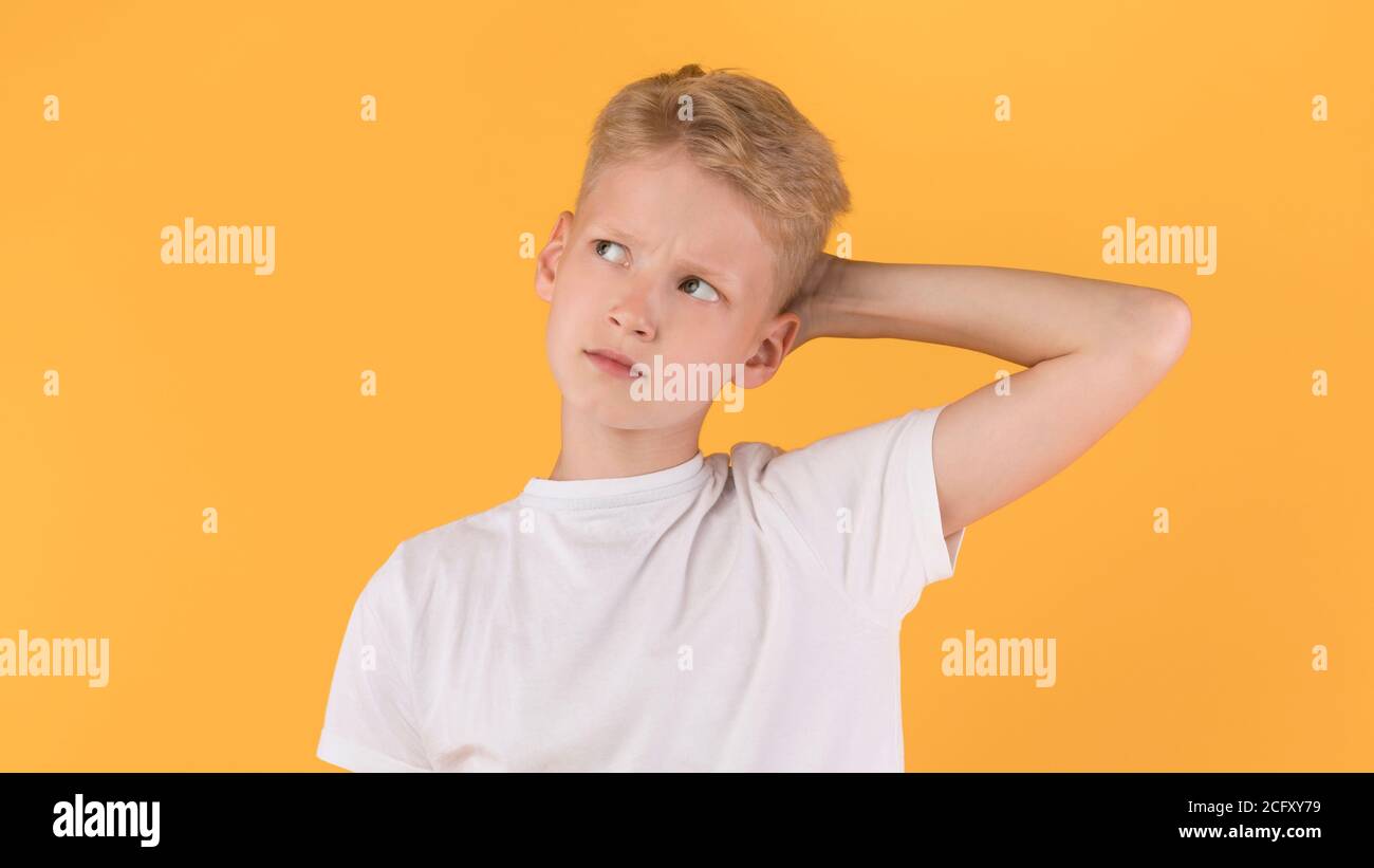 Confused puzzled male kid scratching head at studio Stock Photo - Alamy
