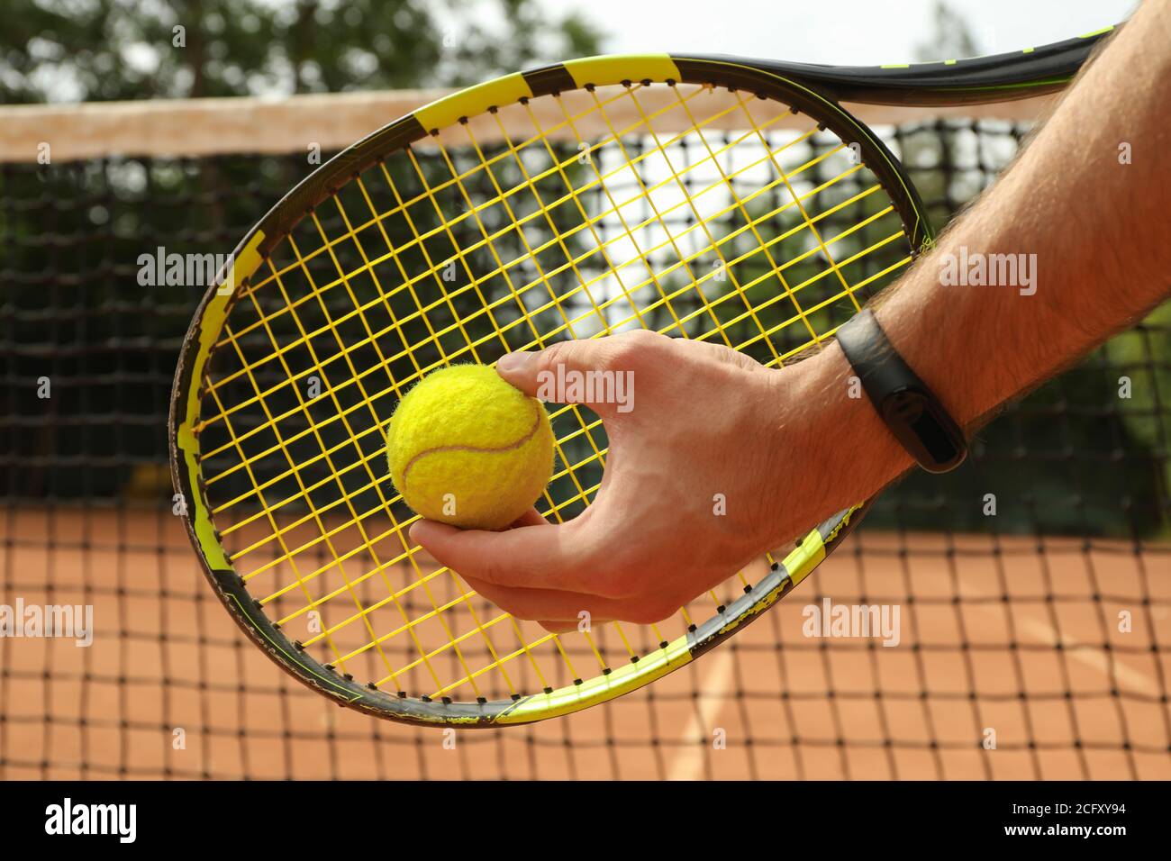 Man hold racket and tennis ball, close up Stock Photo - Alamy
