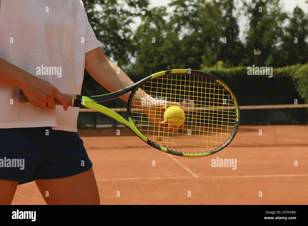 Woman hold racket and tennis ball on clay court Stock Photo - Alamy