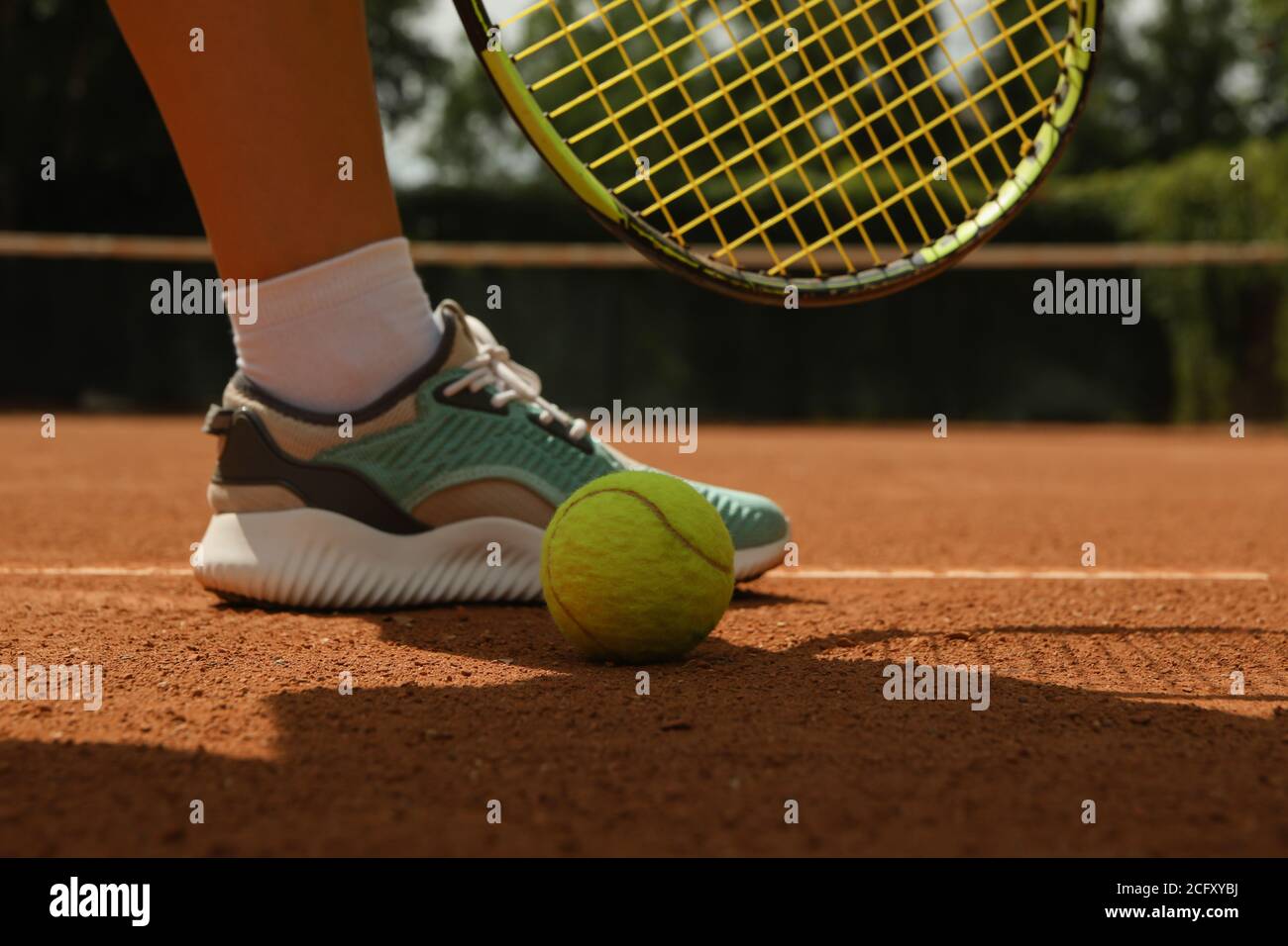 Woman leg, racket and tennis ball on clay court Stock Photo - Alamy