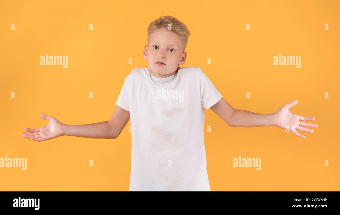 Confused puzzled male kid shrugging at studio Stock Photo - Alamy