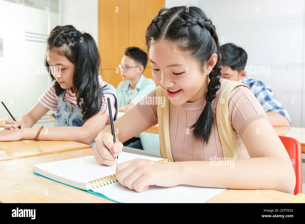 School children writing in textbooks Stock Photo - Alamy