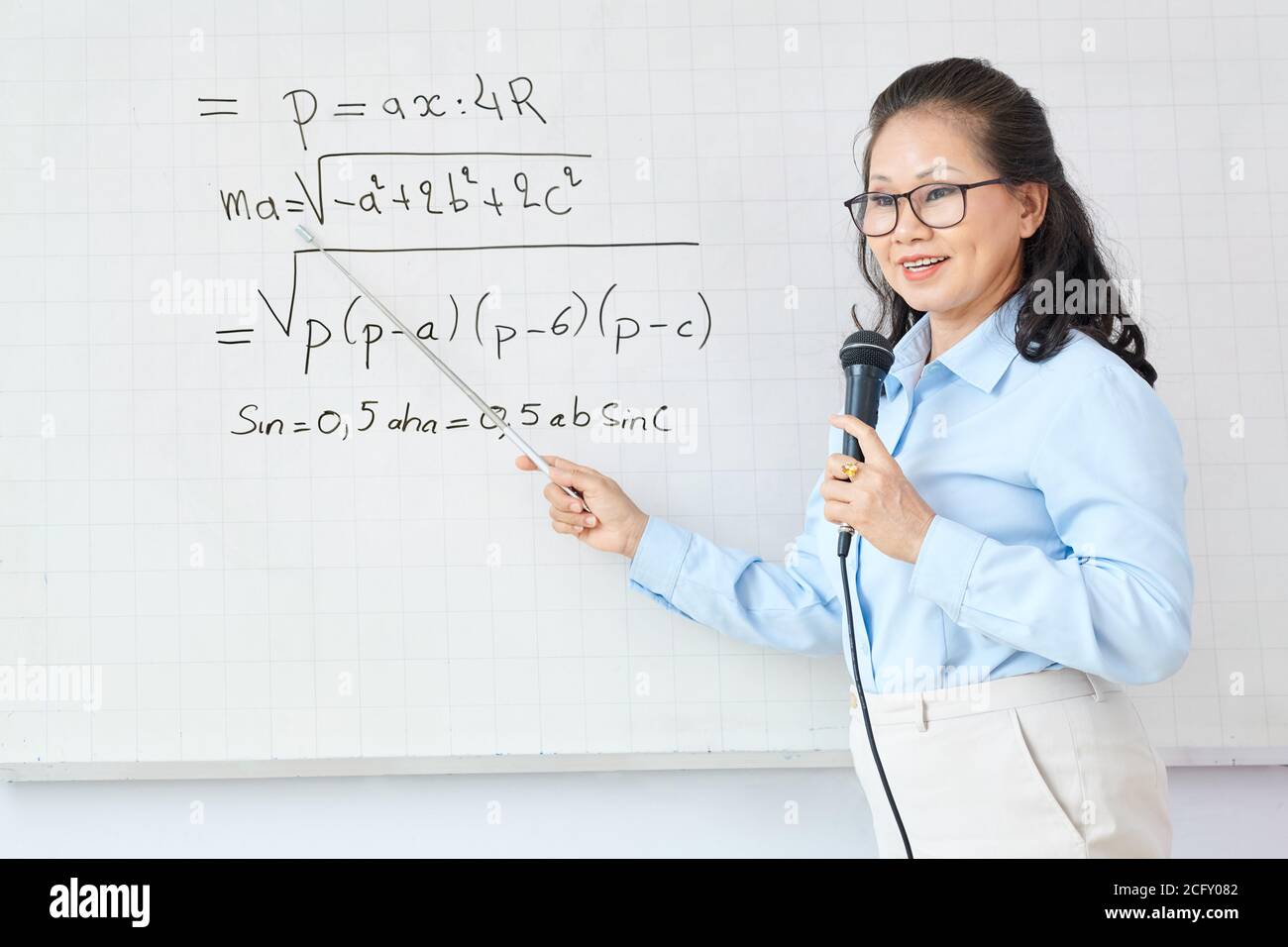 Math teacher explaining topic Stock Photo - Alamy