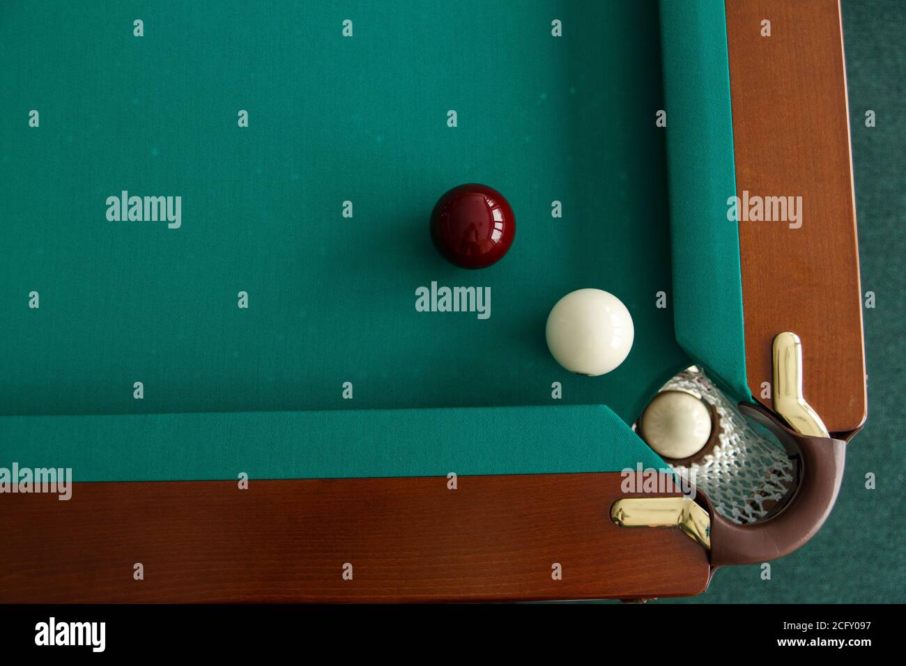 A pool table. Top view. The ball rolls into the pocket. Greencloth ...