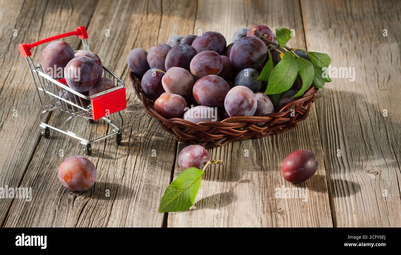 The benefits of plums for the human body.Shopping cart with ripe plums ...