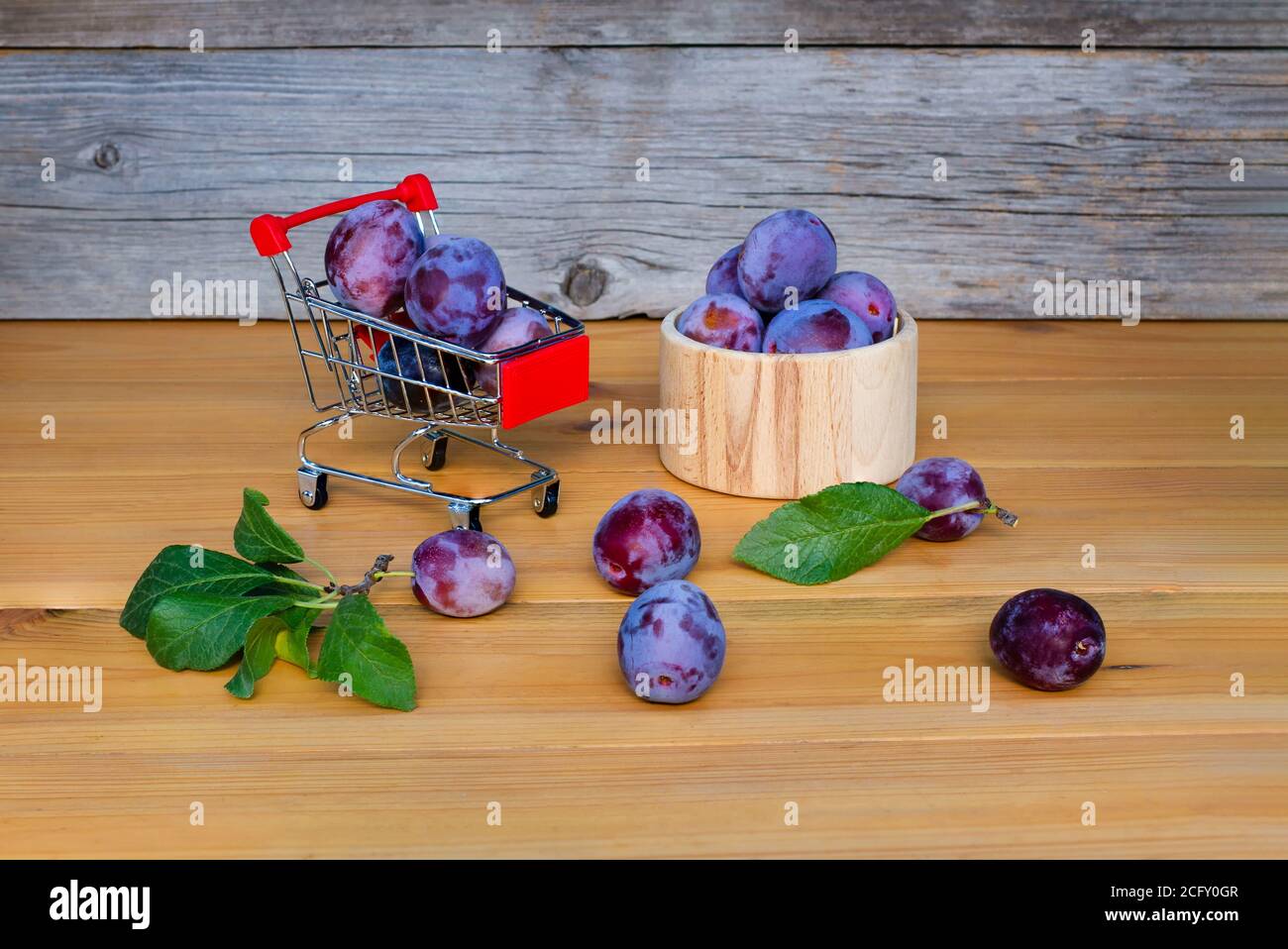 The benefits of plums for the human body.Shopping cart with ripe plums ...