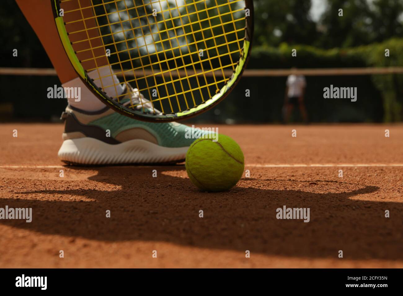 Woman leg, racket and tennis ball on clay court Stock Photo - Alamy
