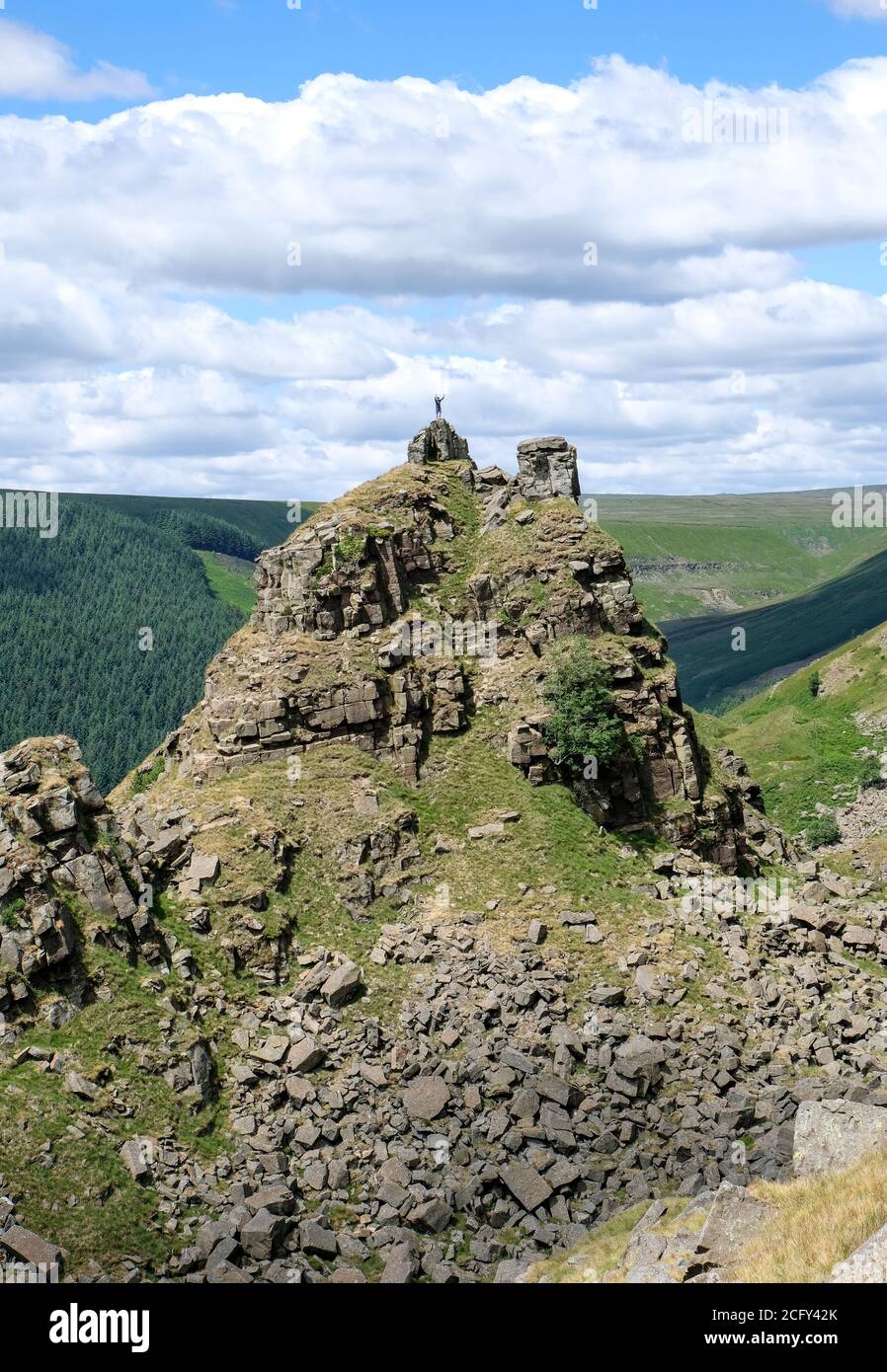 A distant figure stands atop Alport Castles in the Peak District UK ...