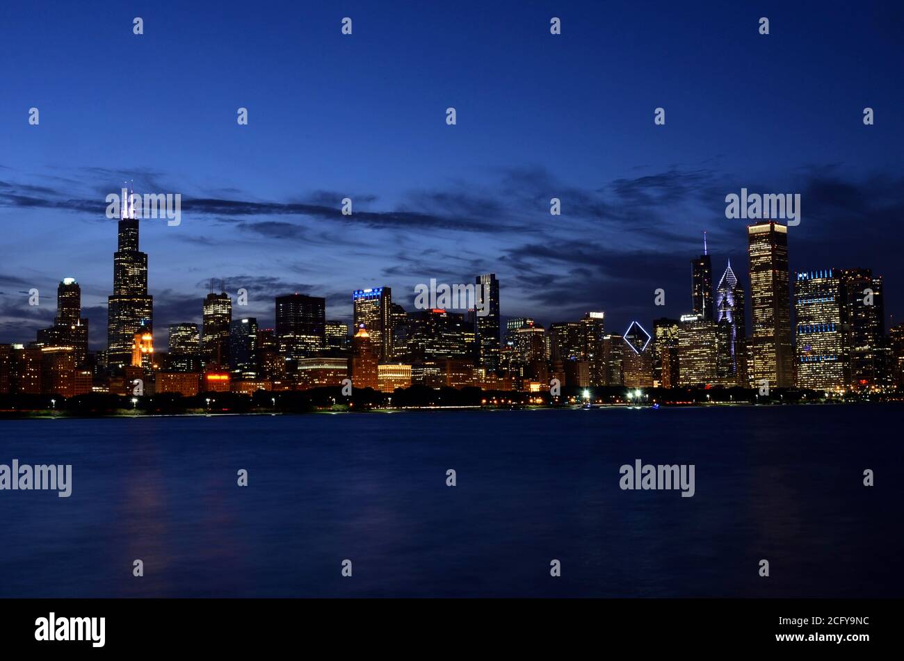 Chicago skyline at night with lights and reflections in Lake Michigan ...