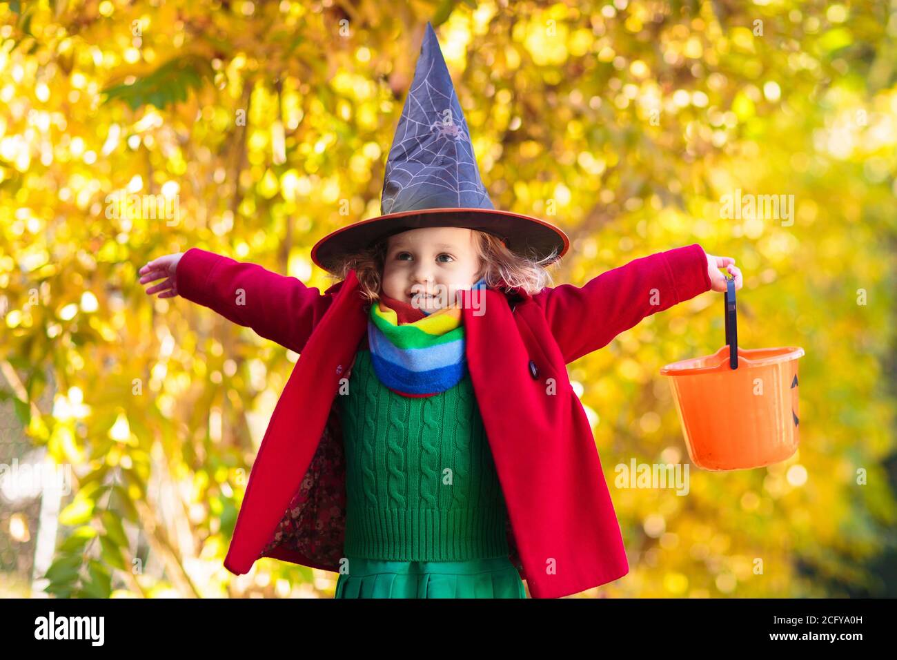 Kids trick or treat on Halloween night. Little girl with pumpkin face ...