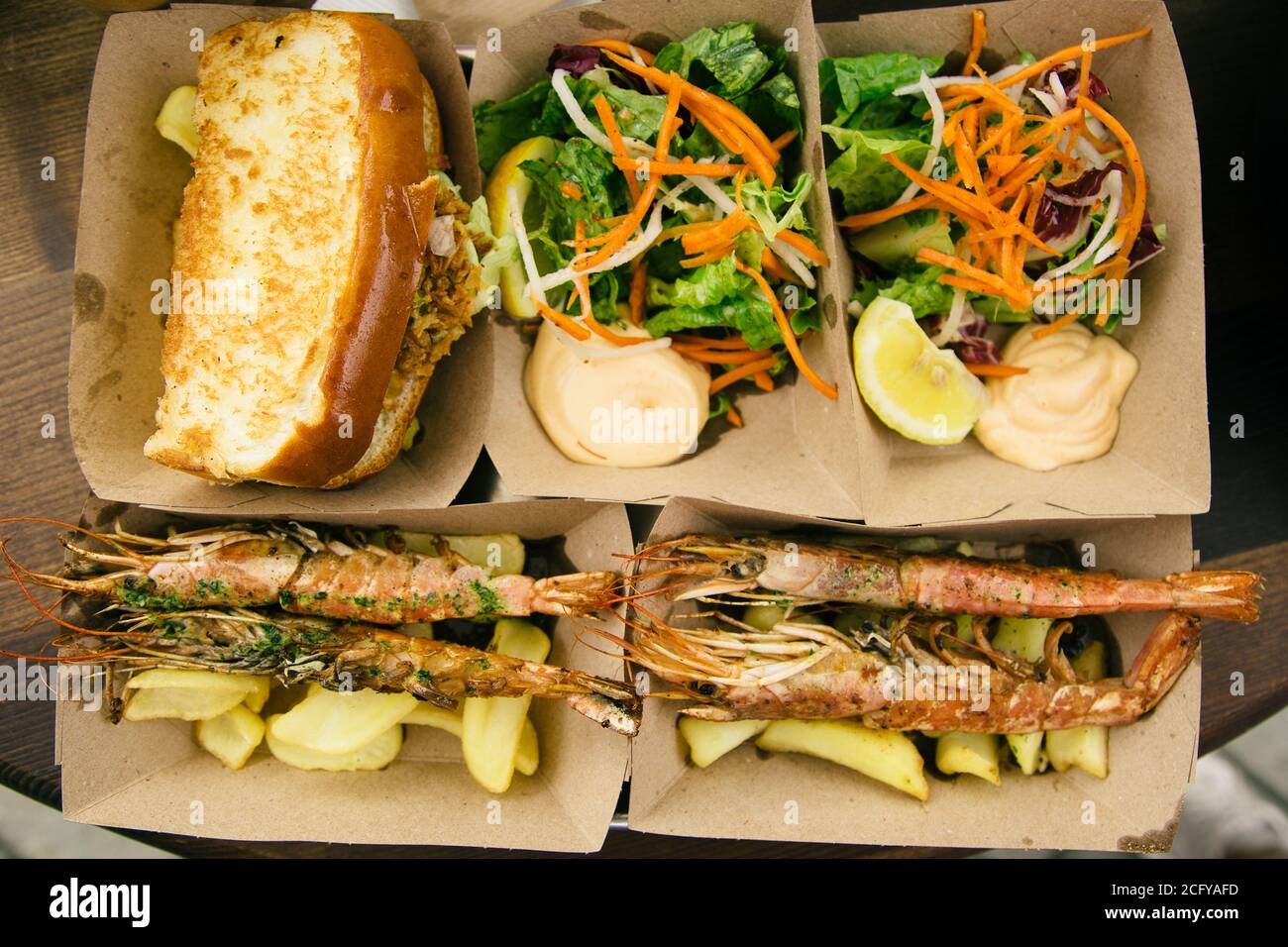 Sea food in paper boxes on the table. Street food Stock Photo - Alamy