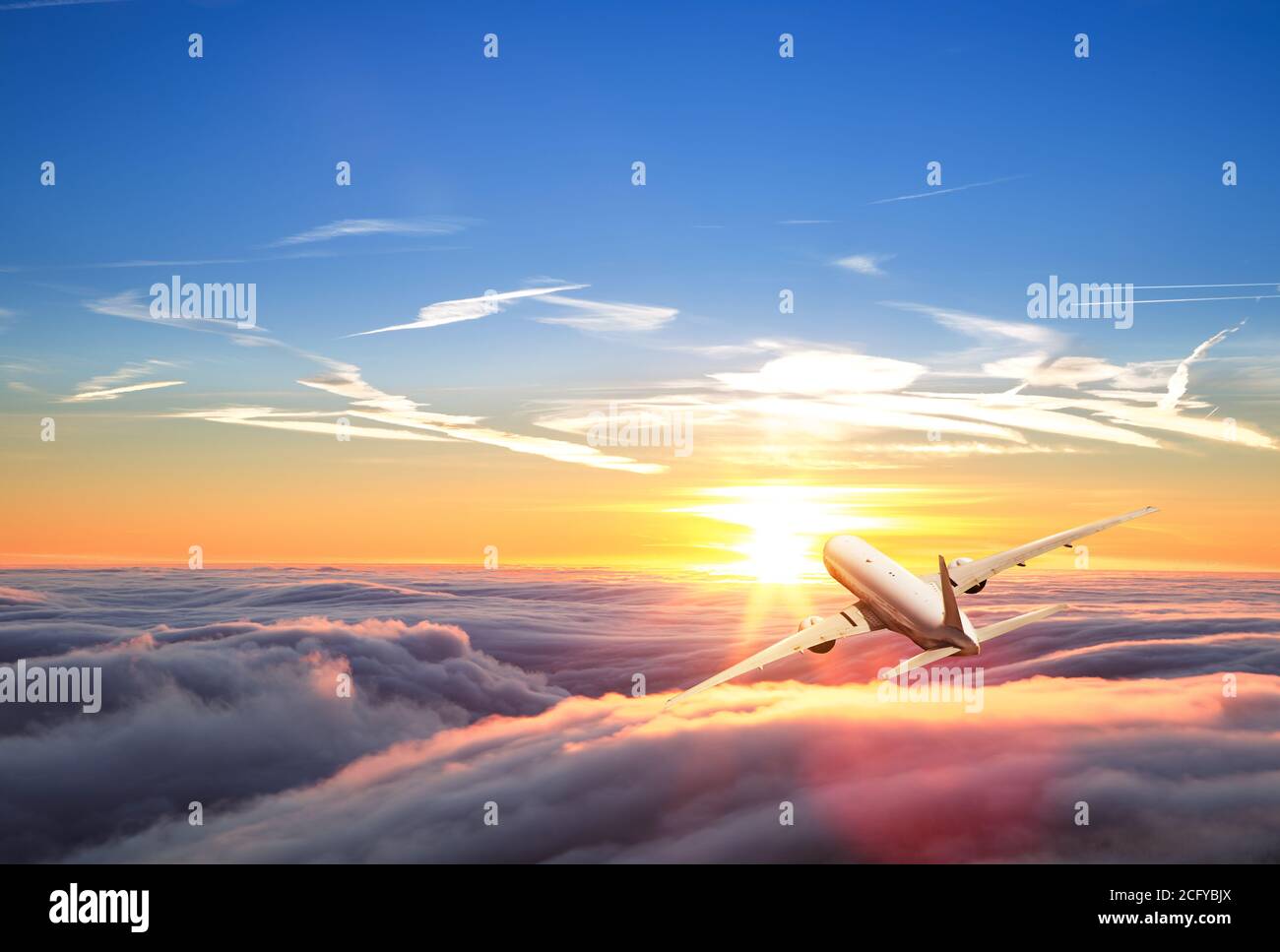 Back view of commercial airplane flying above clouds. Panoramic size ...
