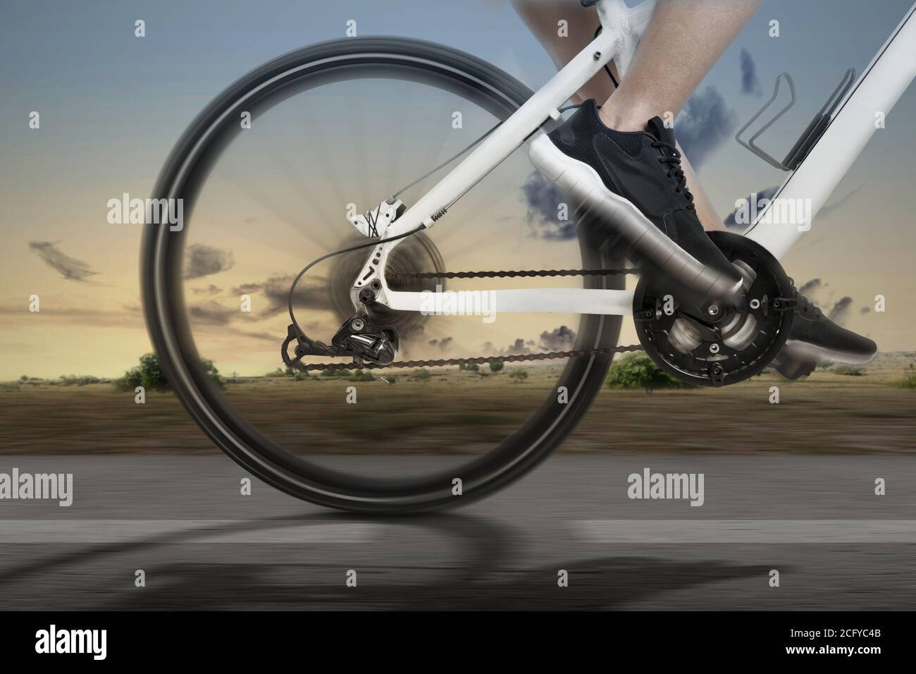 Side view of a woman riding a bicycle on the street Stock Photo - Alamy