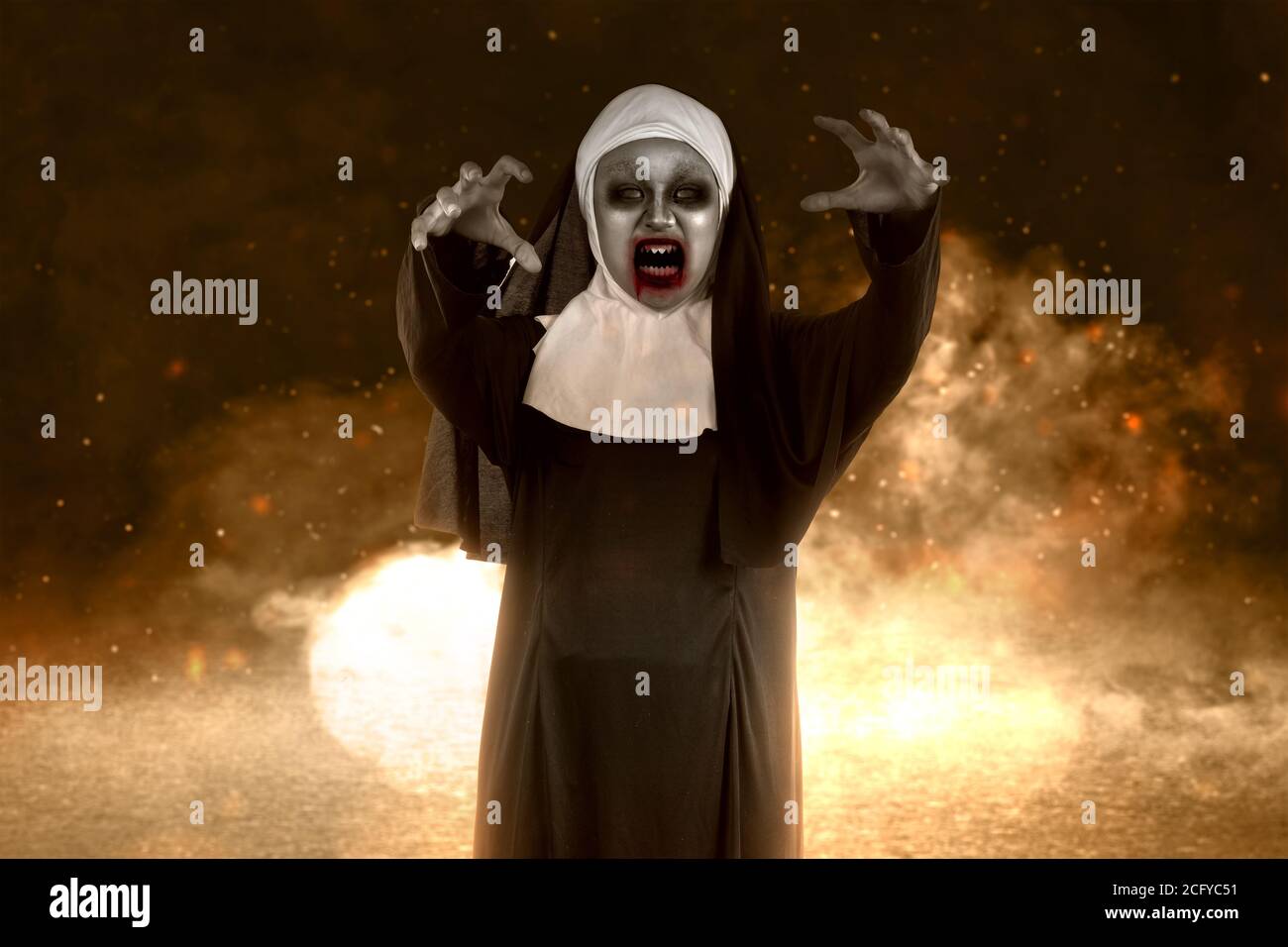Scary devil nun standing with the explosion background Stock Photo - Alamy