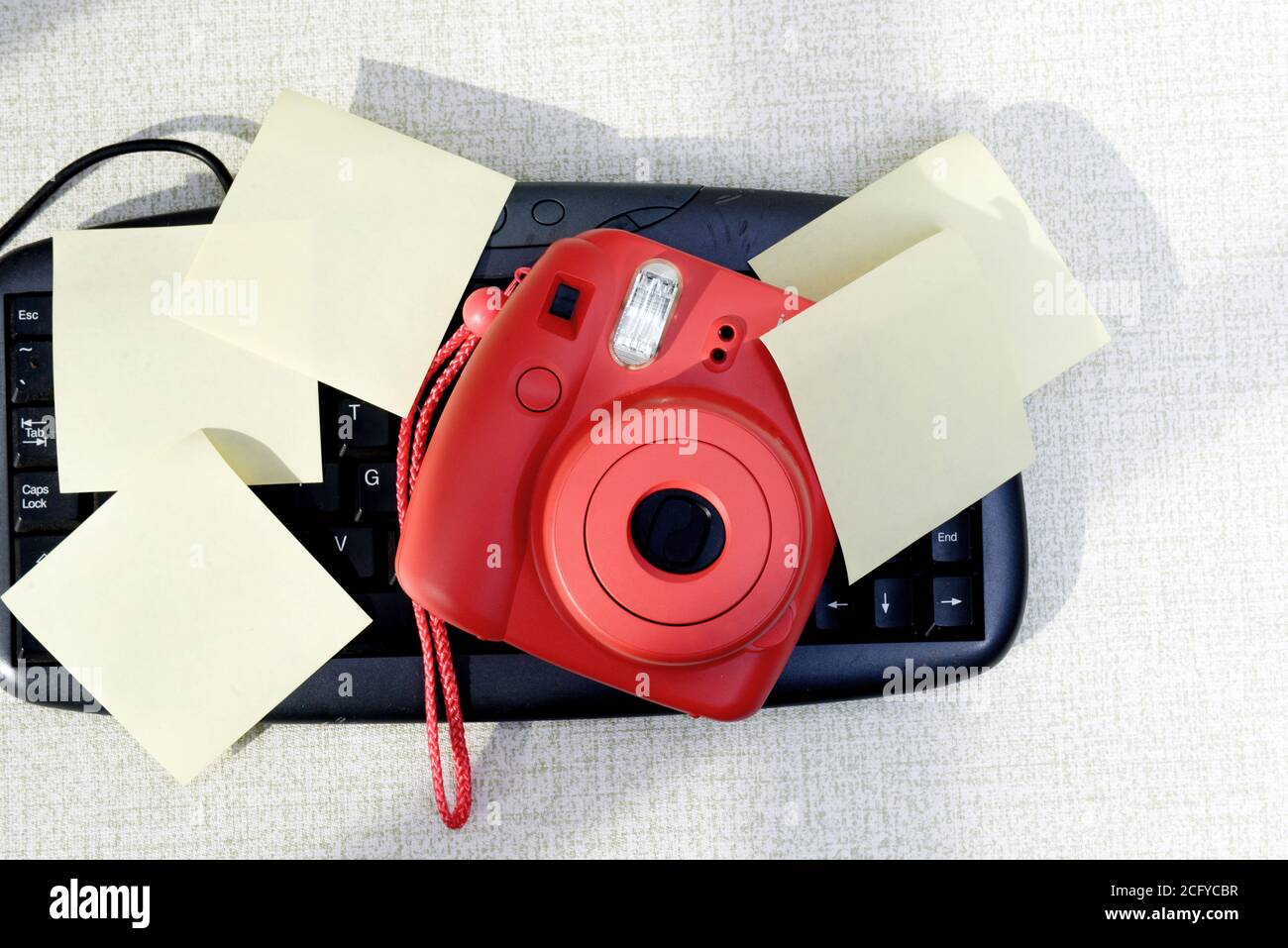 Top view of the camera, computer keyboard, and sticky notes on a flat ...