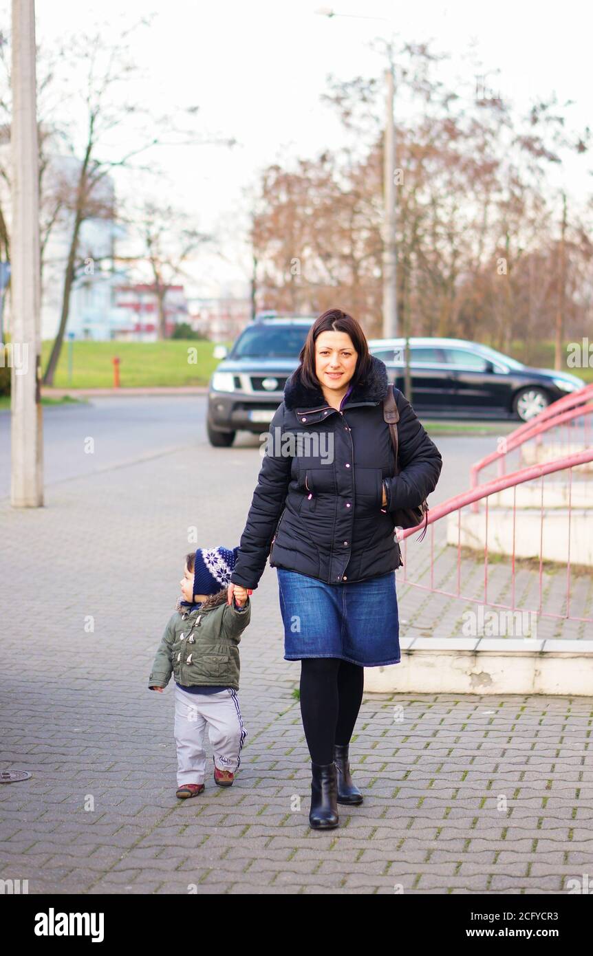 POZNAN, POLAND - Dec 27, 2015: Woman walking with child holding hand on ...