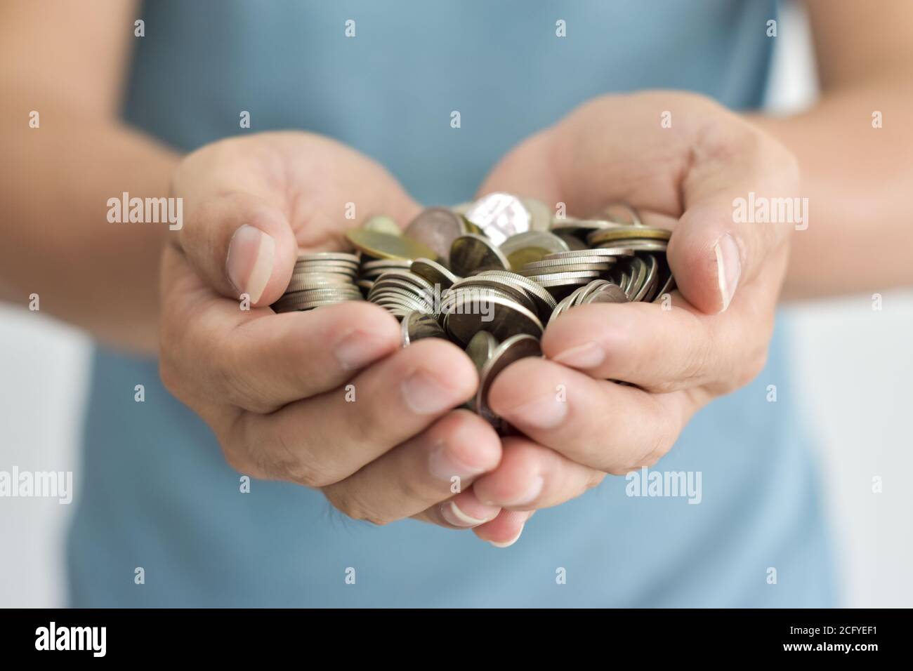 Coins in two hands. Concept money saving Stock Photo - Alamy