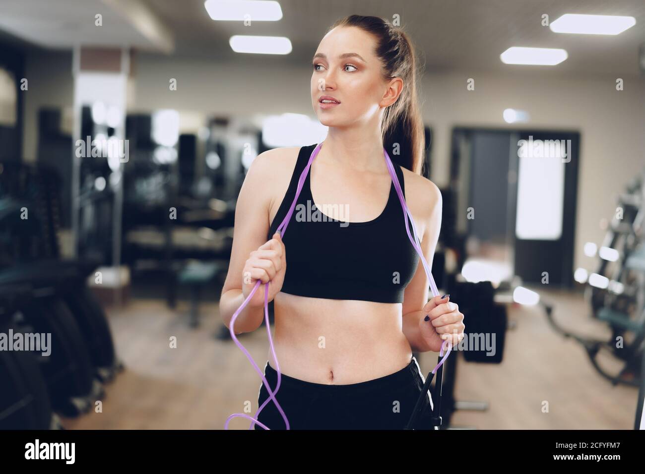 Portrait of a fit girl with jumping rope standing in a gym Stock Photo ...