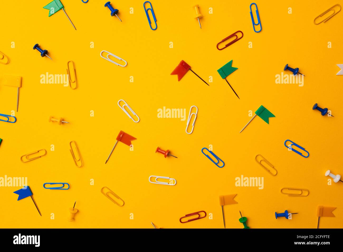 Color push pins pattern on yellow background Stock Photo - Alamy