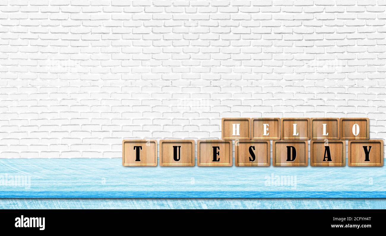 Hello Tuesday alphabet letters put on blue table with white brick wall ...