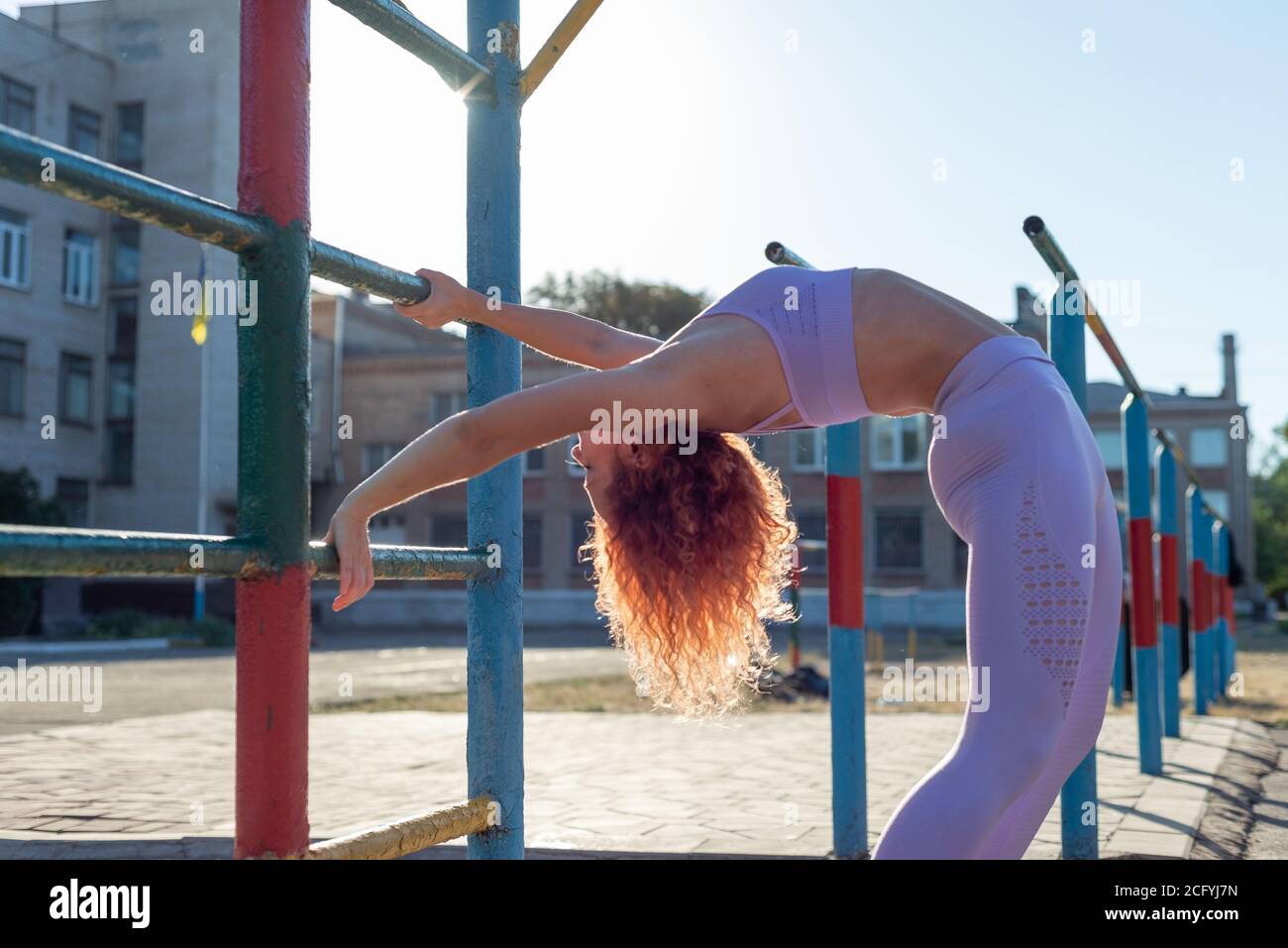 a young athlete does an exercise in the arch of the spine to stretch ...