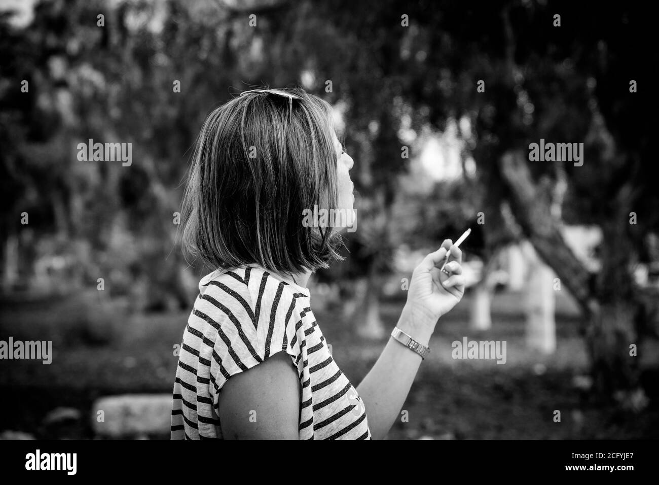 Woman smoking in a park, profile view, black and white Stock Photo - Alamy