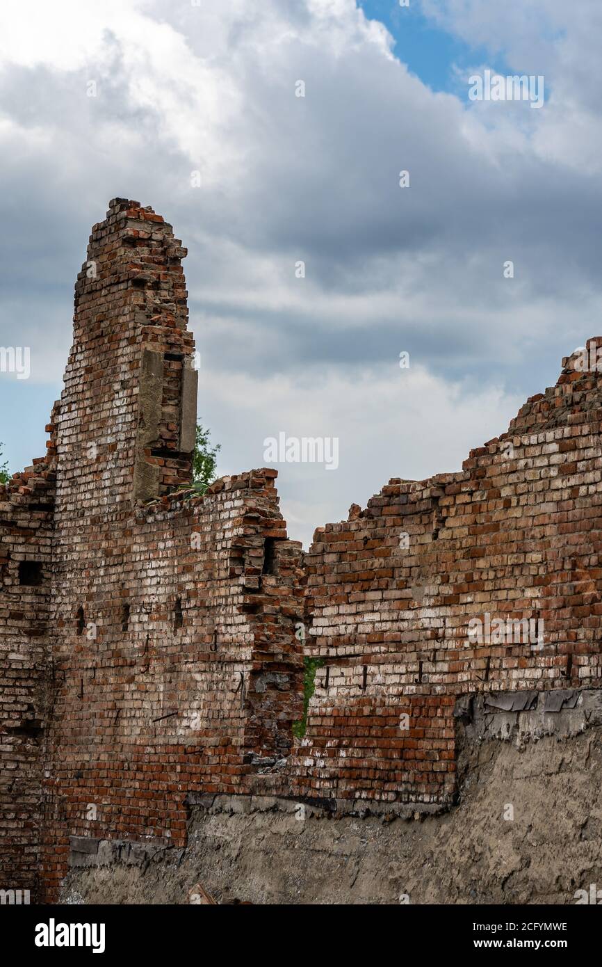 Destroyed wall. Fragments of the wall against the sky. Ruins of houses ...