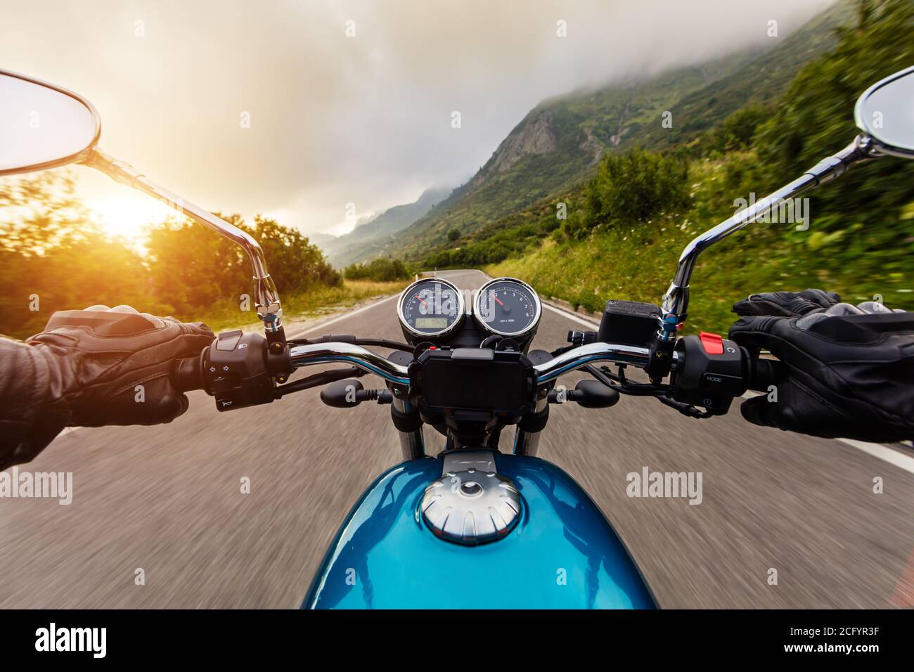 View from motorcycle driver perspective riding in Alpine landscape ...