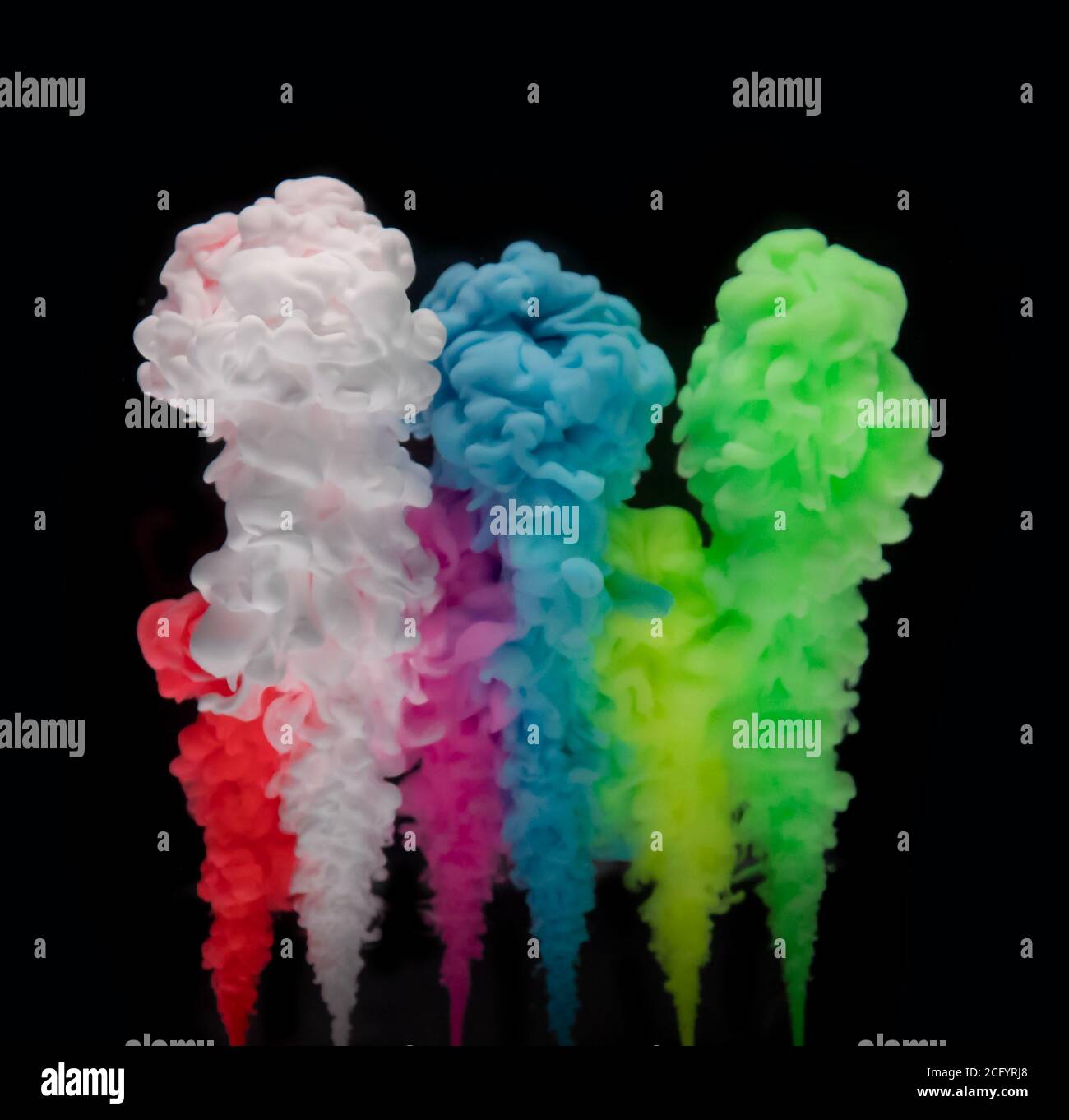 Coloured acrylic ink mixing in water isolated on black background ...