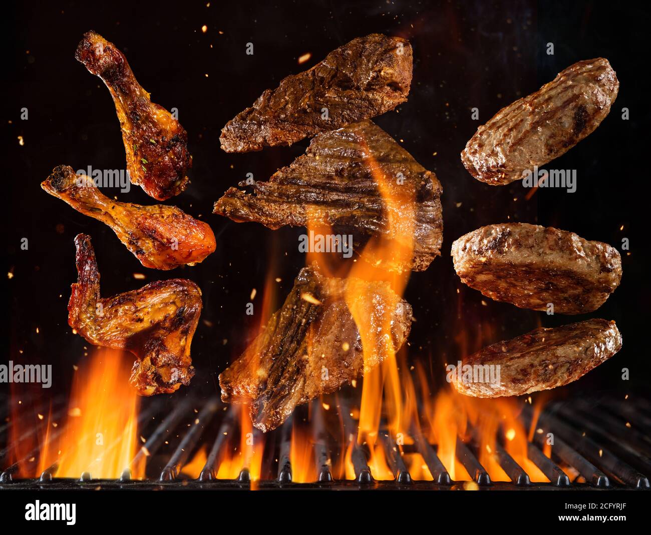 Flying beef steaks, hamburgers and chicken pieces above burning grill ...