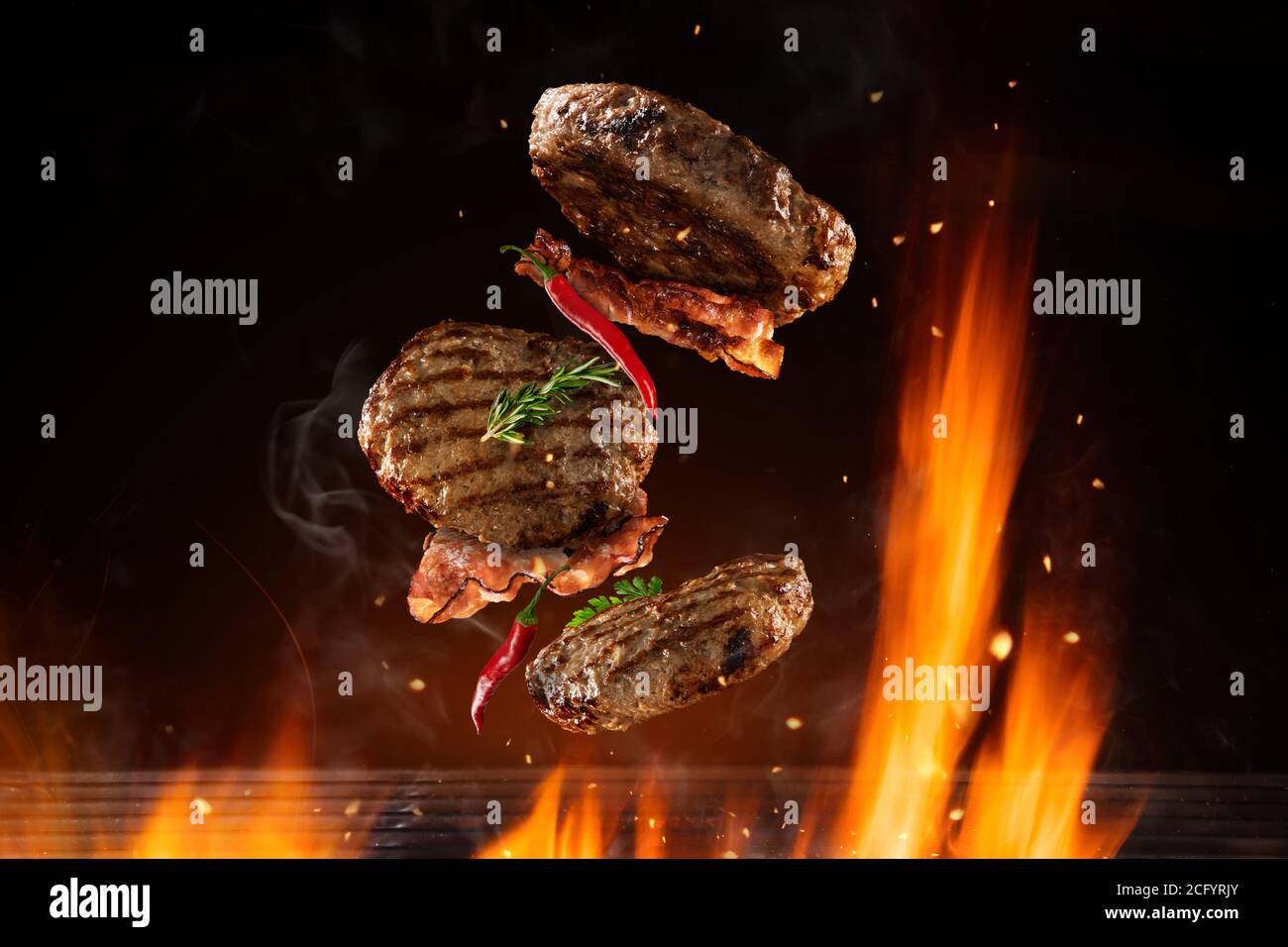 Flying beef hamburgers pieces above burning grill grid, isolated on ...