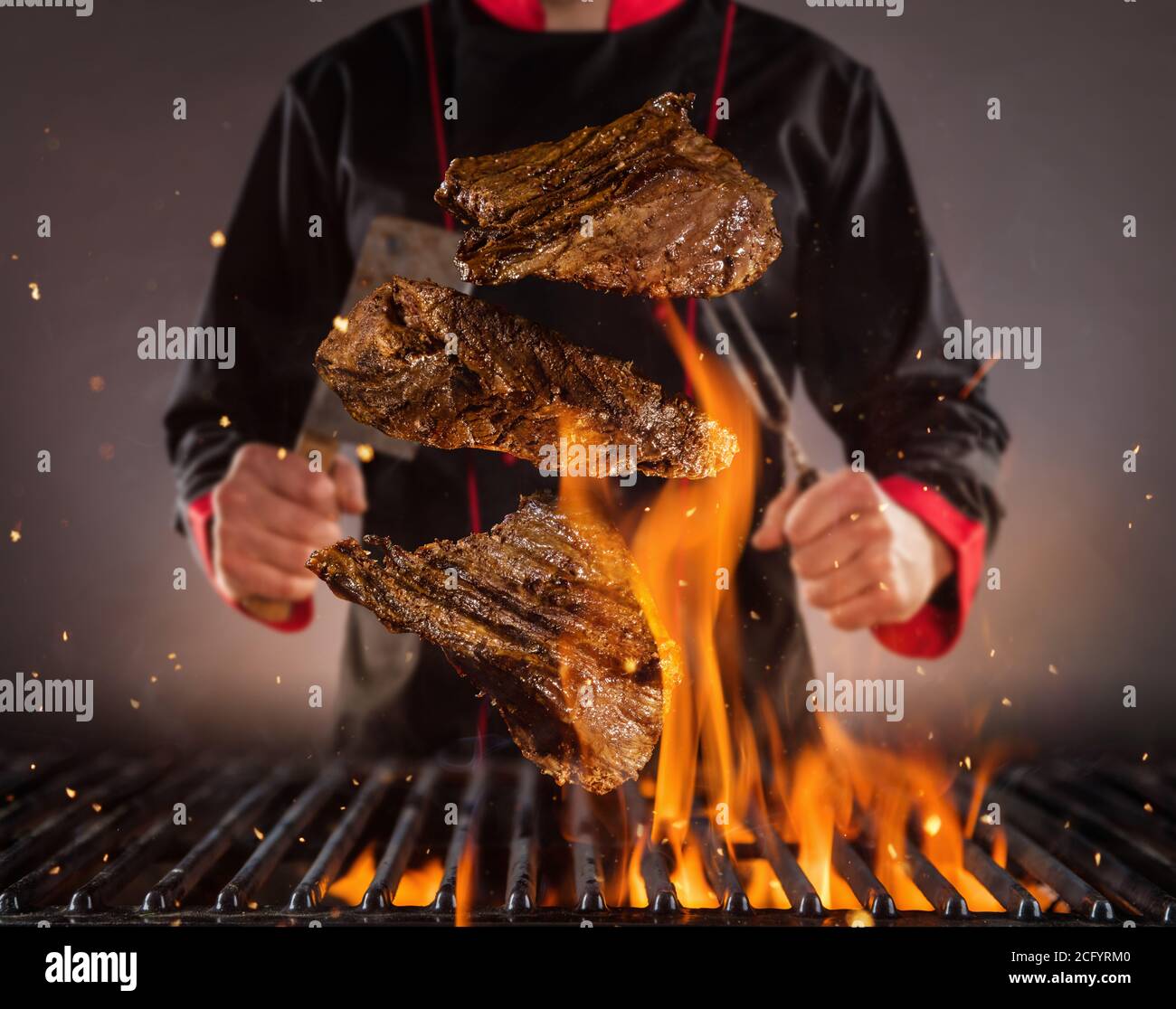 Flying beef steaks above the grill with chef on background. Concept of ...