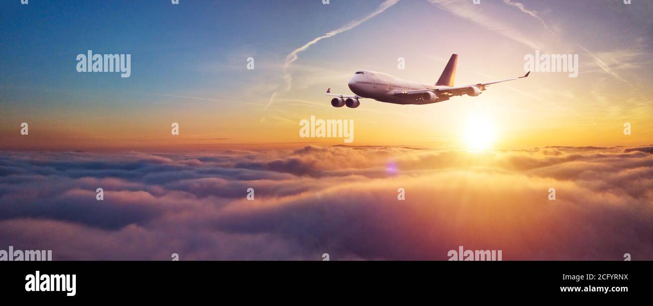 Huge commercial airplane flying over dramatic sunset sky. Jet plane is ...