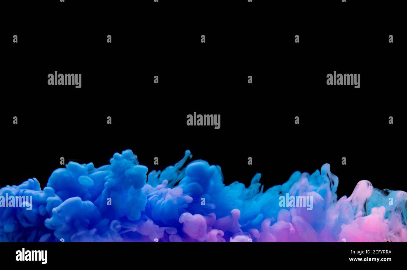 Coloured acrylic ink mixing in water isolated on black background ...