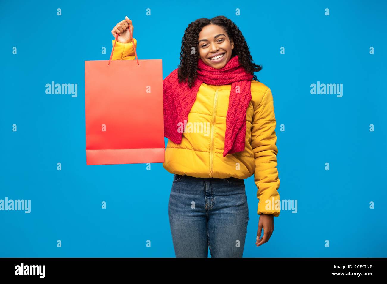 Black Girl Holding Shopping Bag Standing Over Blue Studio Background ...