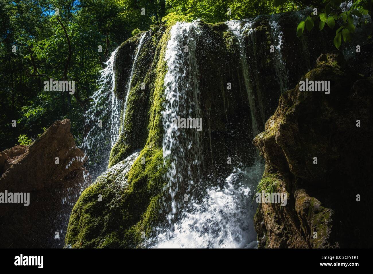 A beautiful waterfall deep in the tropical forest, steep mountain ...