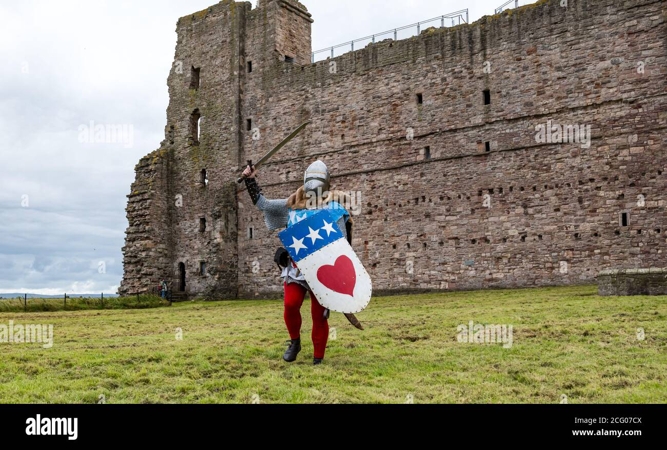 Man dressed as medieval knight with sword, hemet & shield wearing face ...