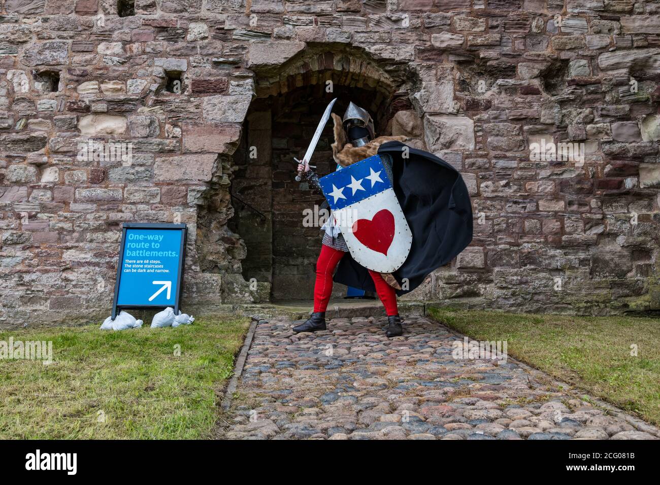 Man dressed as medieval knight with sword, hemet & shield wearing face ...