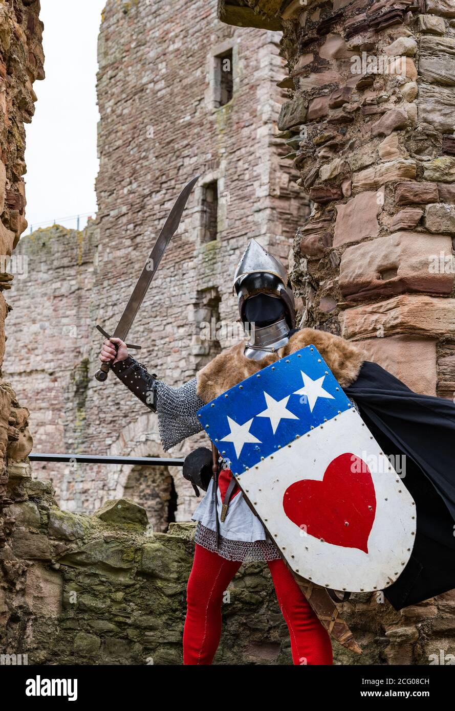 Man dressed as medieval knight with sword, hemet & shield wearing face ...