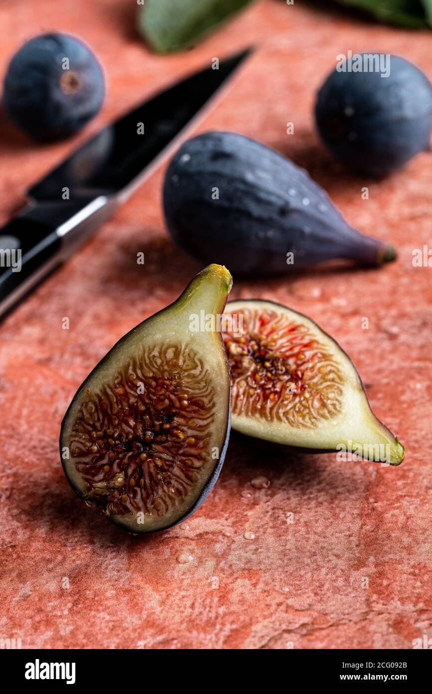 Halved figs against a terra cotta backdrop Stock Photo - Alamy