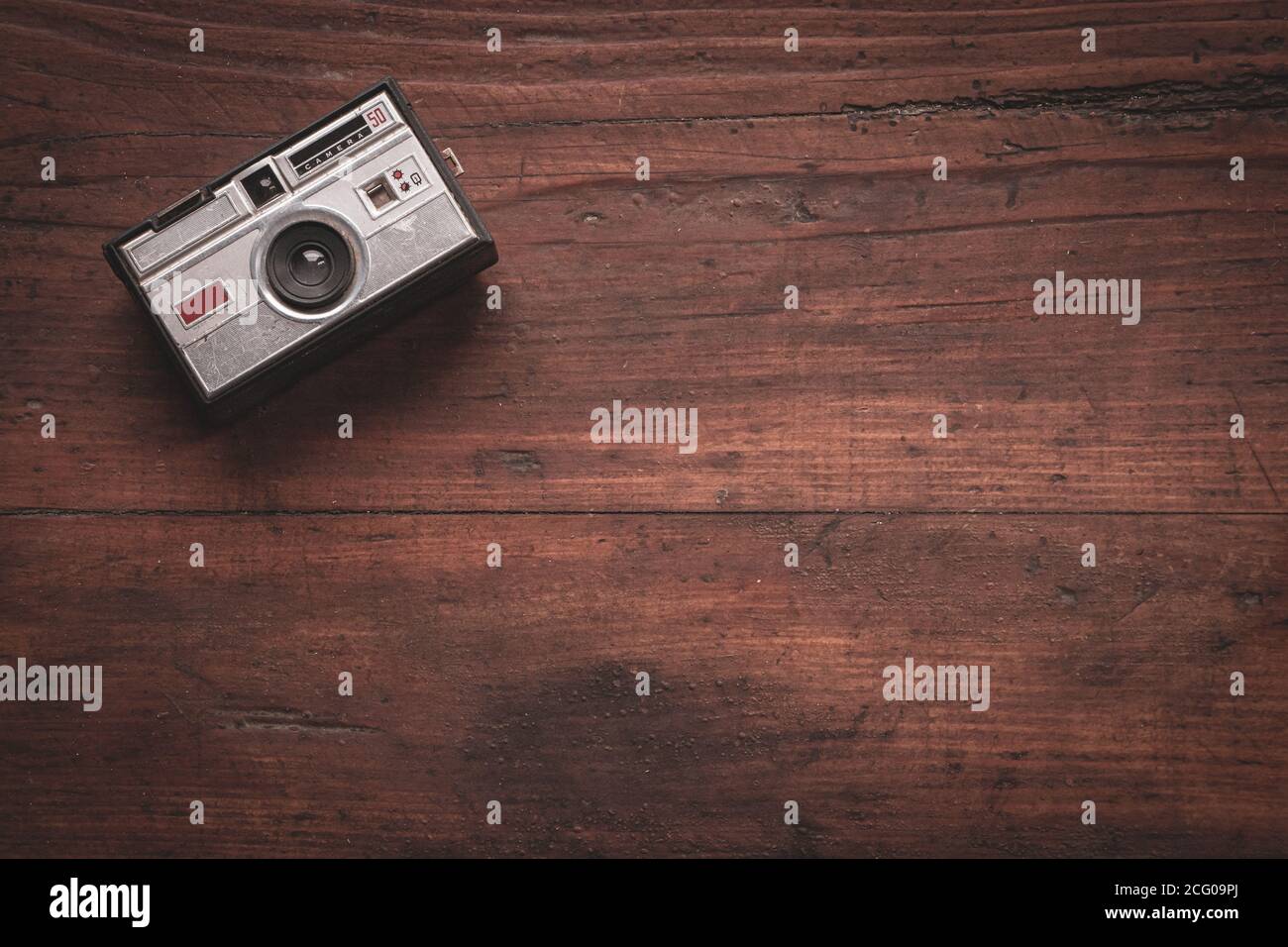 Old and worn photo camera from the 60s on rustic wooden table Stock ...