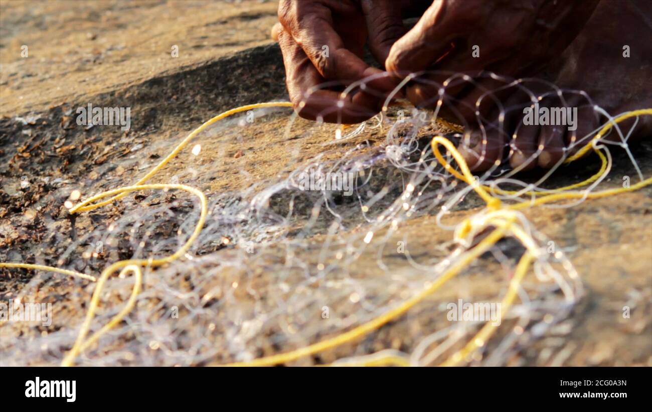 Indian man preparing the fishing net Stock Photo - Alamy