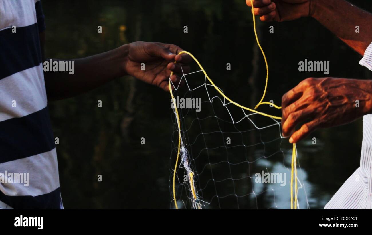 Indian man preparing the fishing net Stock Photo - Alamy