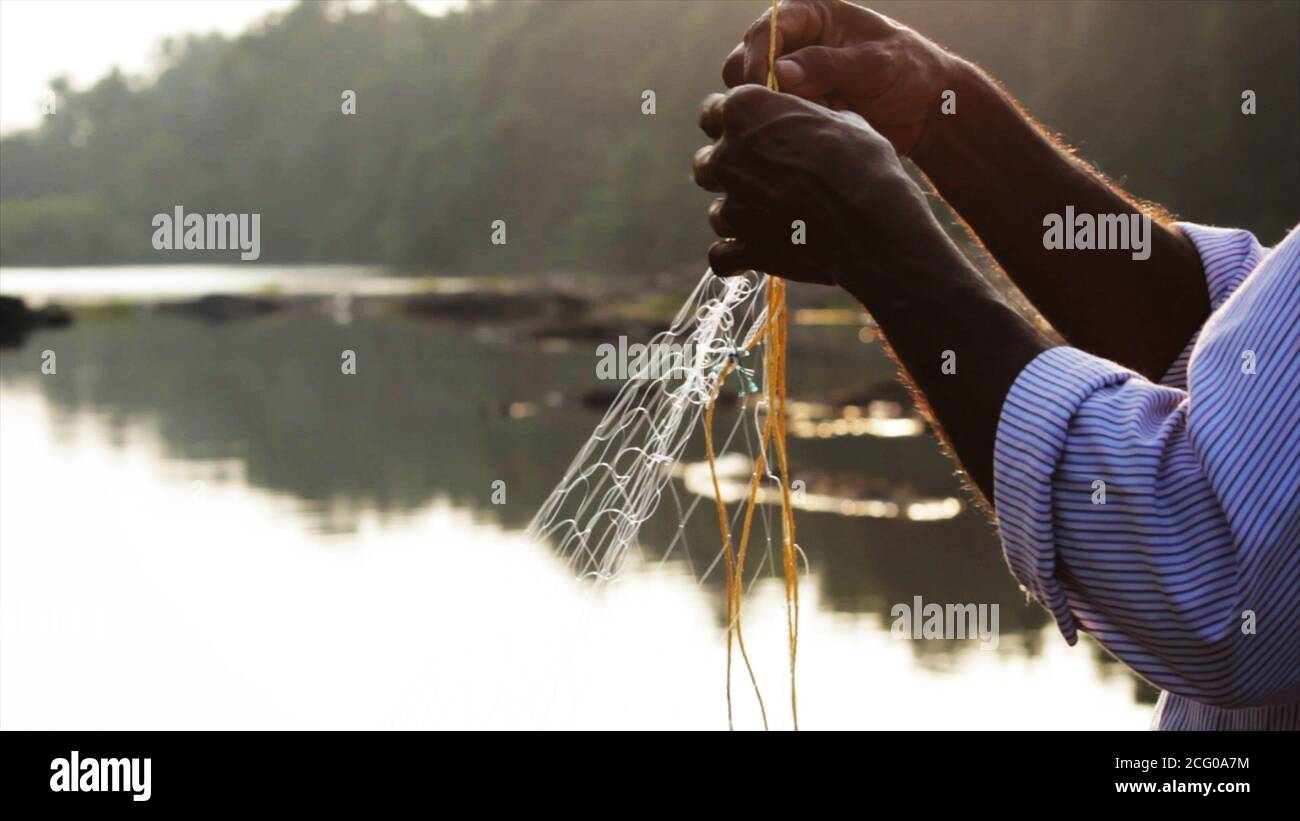Indian man preparing the fishing net Stock Photo - Alamy