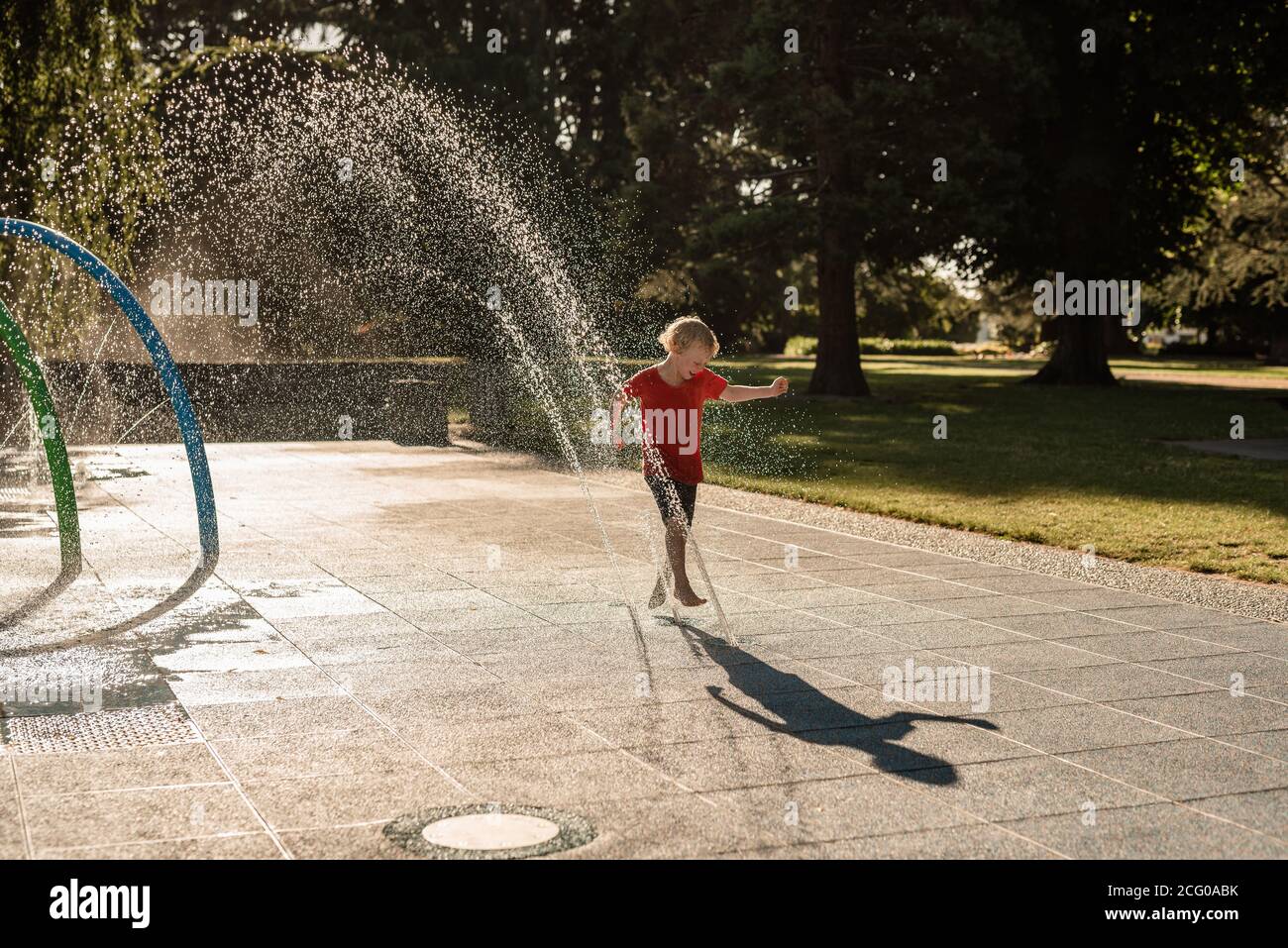 Happy child playing in water at a park Stock Photo - Alamy