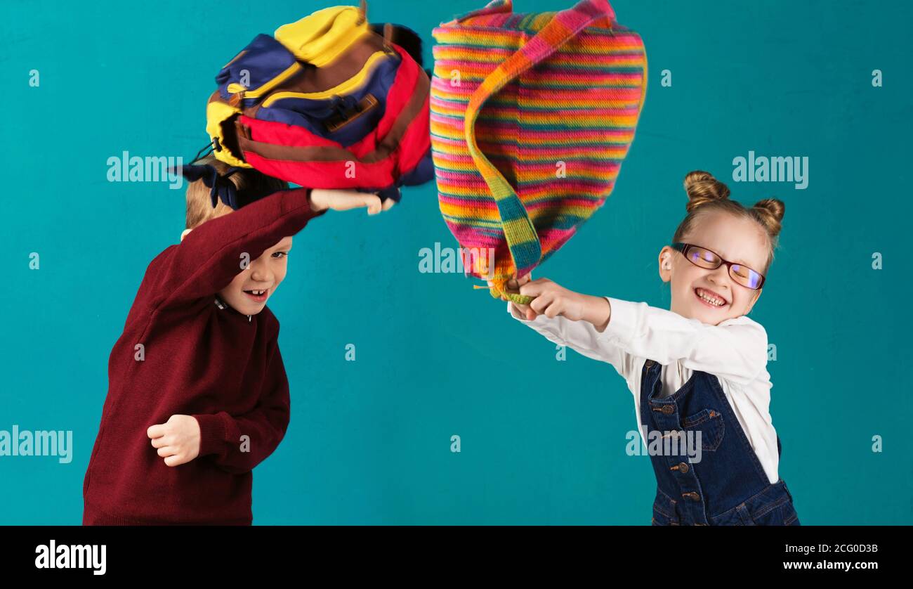 Funny little kids with big backpack jumping and having fun against ...