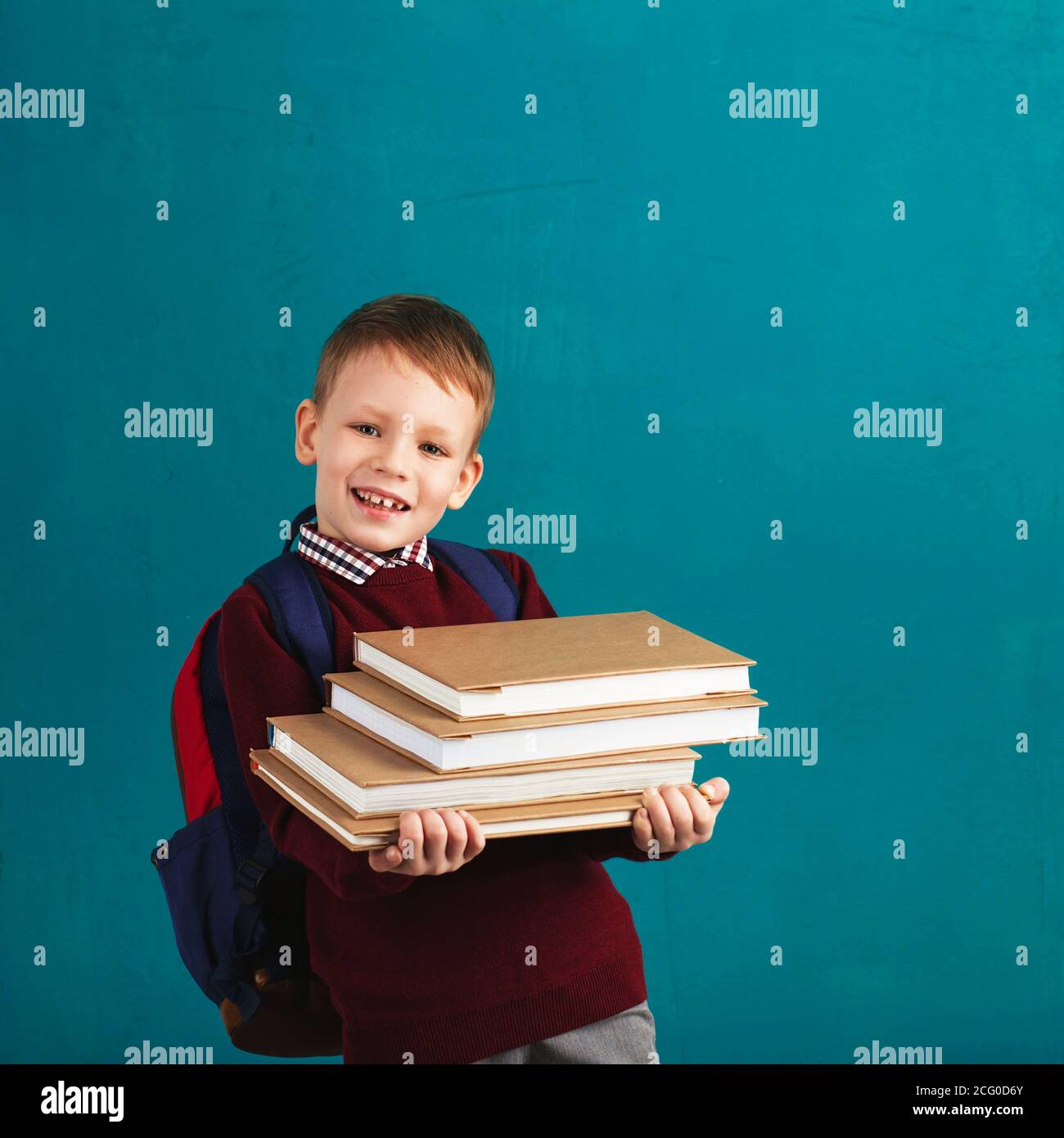 Cheerful thoughtful little school boy in school uniform with backpack ...